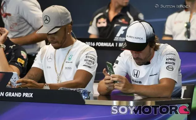 Lewis Hamilton (ឆ្វេង) និង Fernando Alonso (ស្តាំ) ជាមួយនឹងទូរសព្ទដៃរបស់ពួកគេ – SoyMotor.com