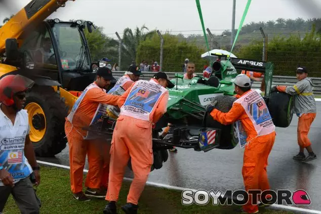 Petugas memindahkan Caterham yang jatuh dari Marcus Ericsson - LaF1